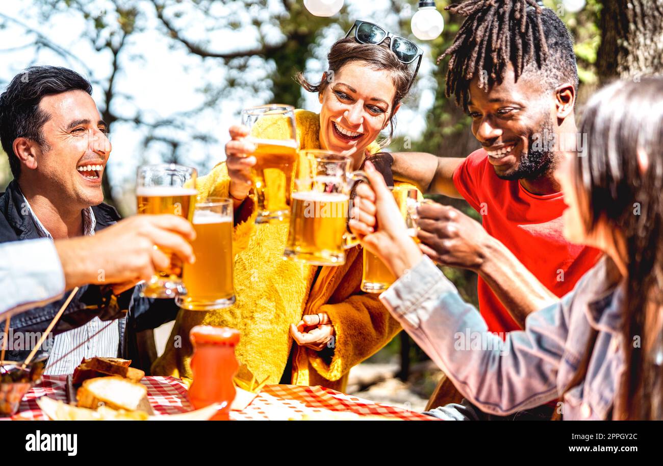 Young friends toasting beer pint at brewery garden venue - Genuine food ...