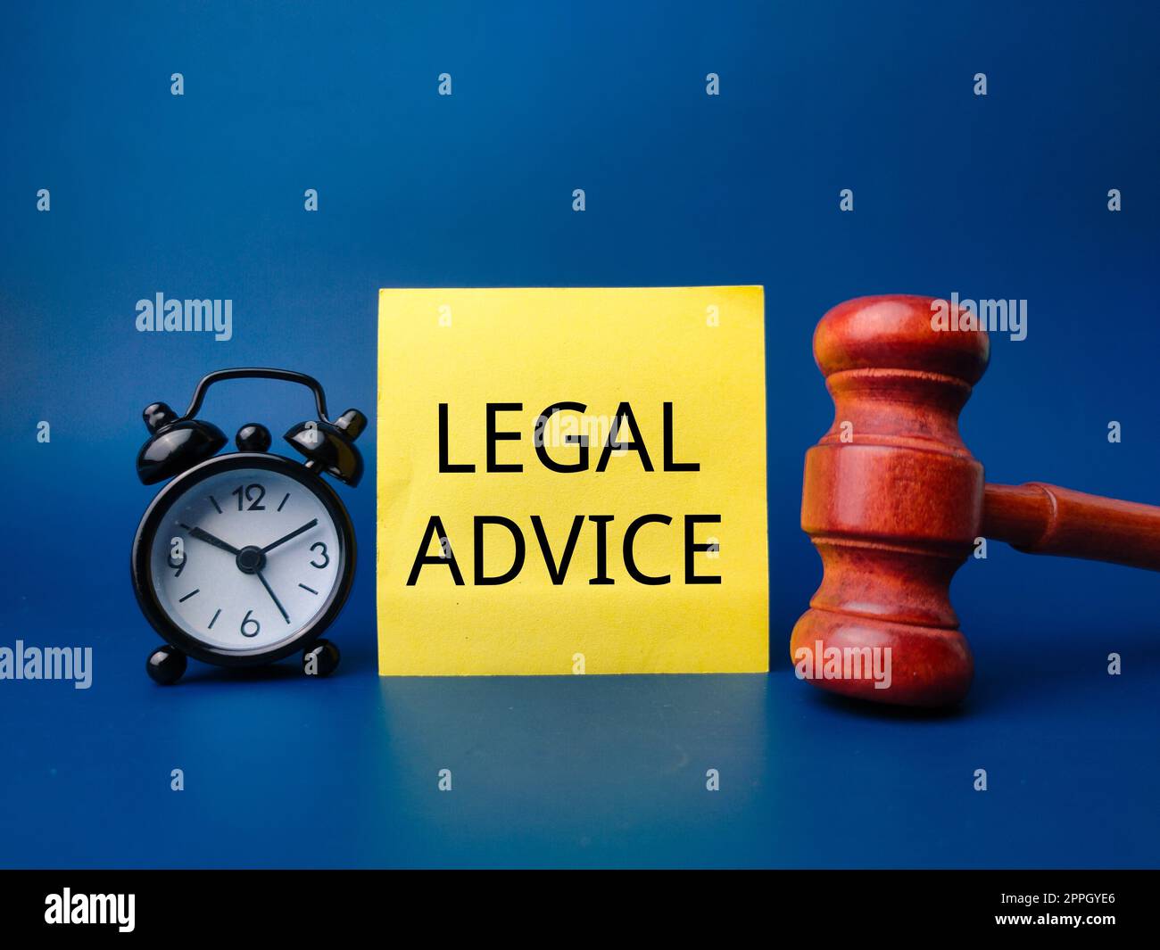 Alarm clock and gavel with the word LEGAL ADVICE on a blue background ...
