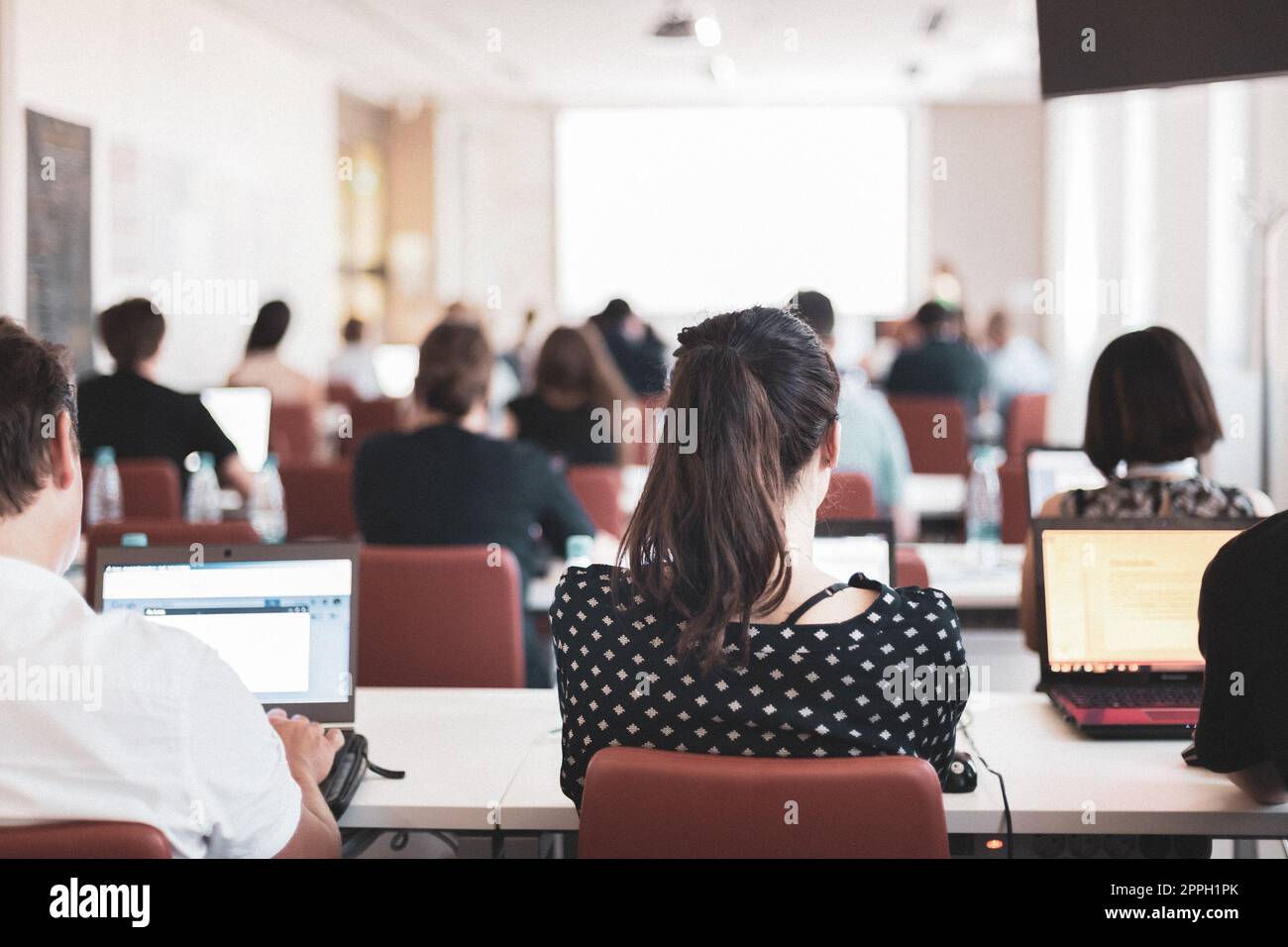 Speaker giving presentation in lecture hall at university. Participants ...