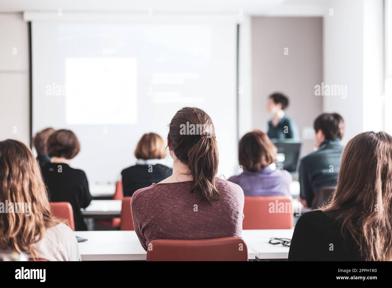 Female speaker giving presentation in lecture hall at university ...