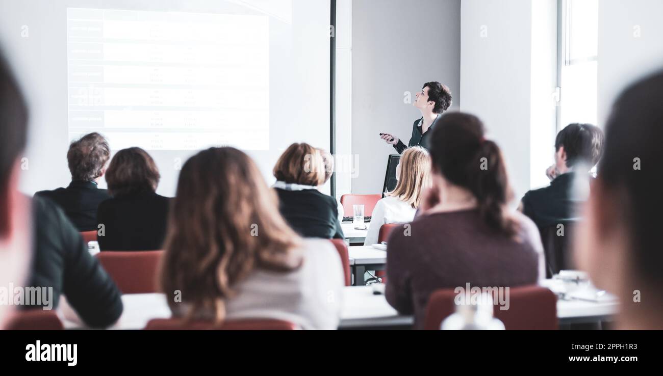 Woman giving presentation in lecture hall at university Stock Photo - Alamy