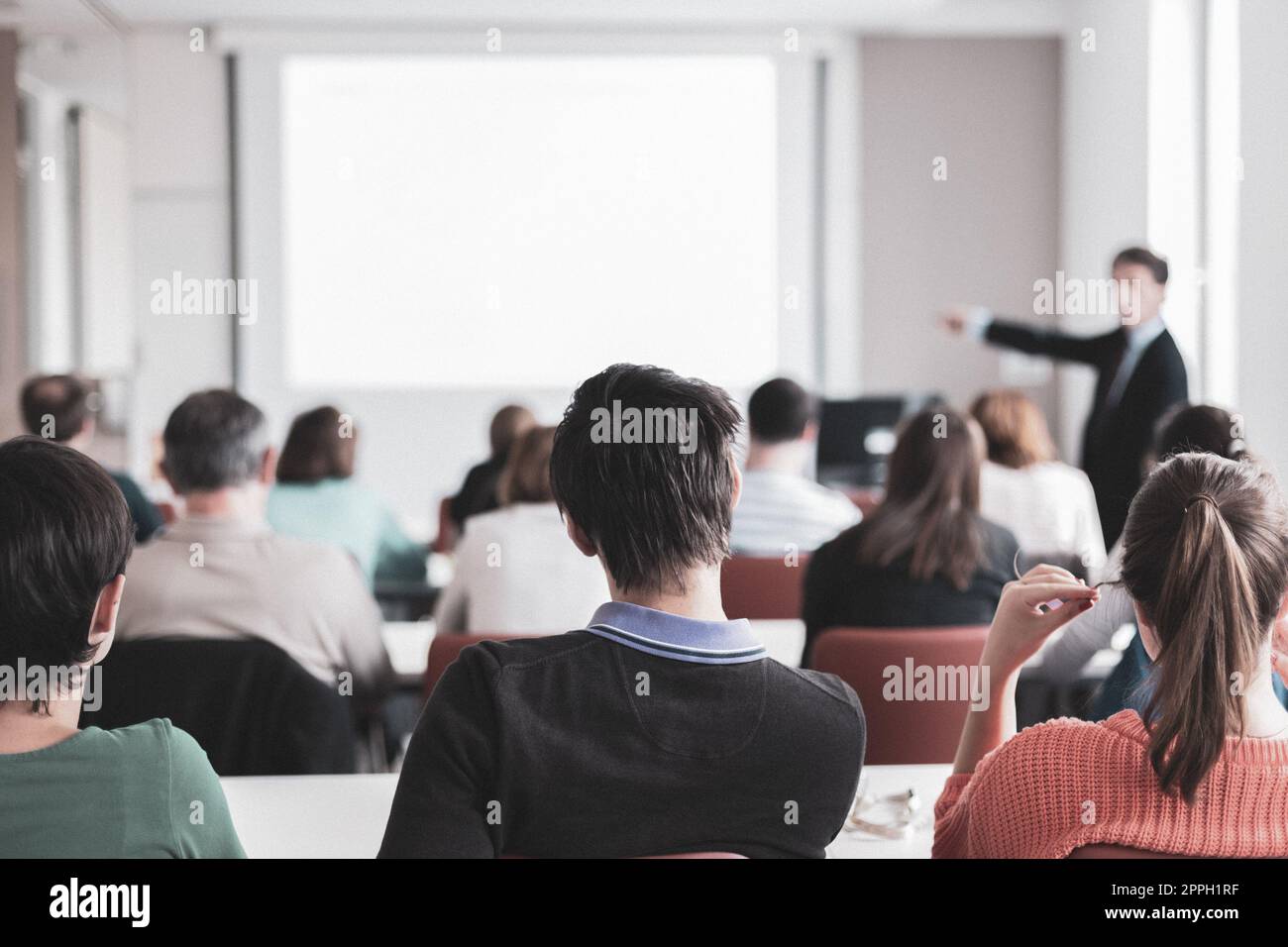 Speaker giving presentation in lecture hall at university. Participants ... Speaker giving presentation in lecture hall at university. Participants ...