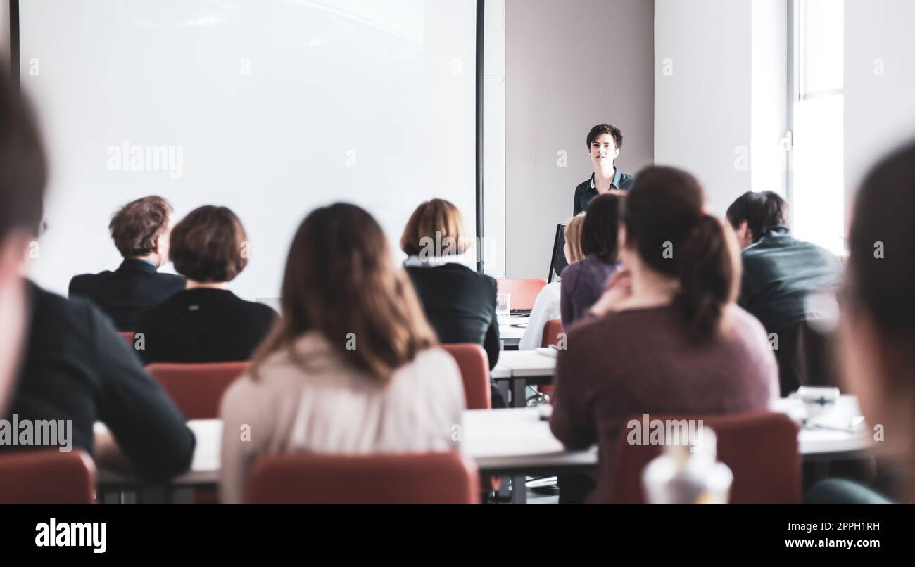 Female speaker giving presentation in lecture hall at university ...