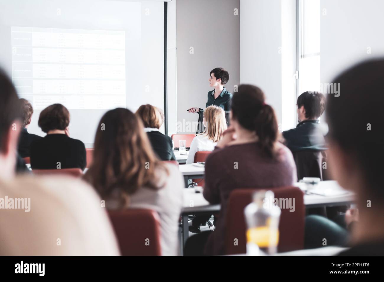 Female speaker giving presentation in lecture hall at university ...