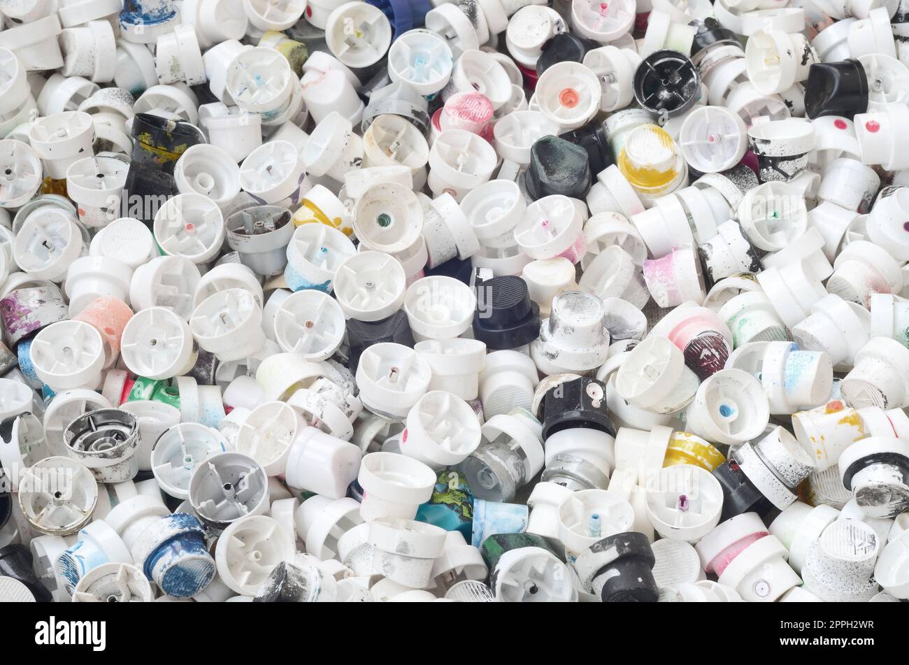 A pattern of many used and soiled nozzles from spray cans with aerosol ...