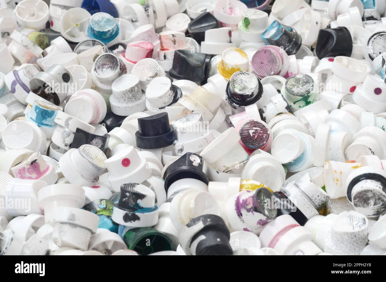 A pattern of many used and soiled nozzles from spray cans with aerosol ...