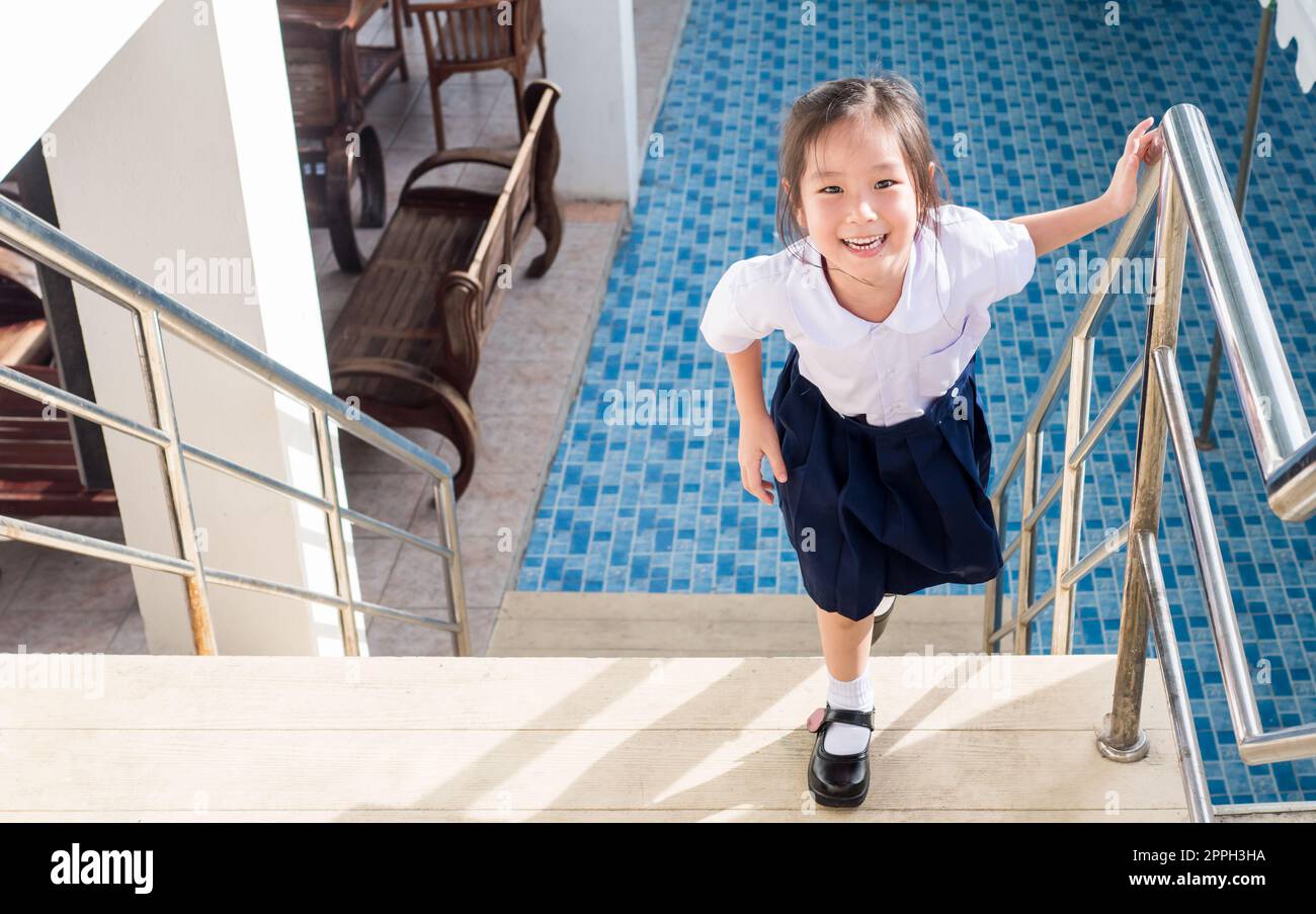 Little Asian girl going up the stairs in the school, uniform Stock ...