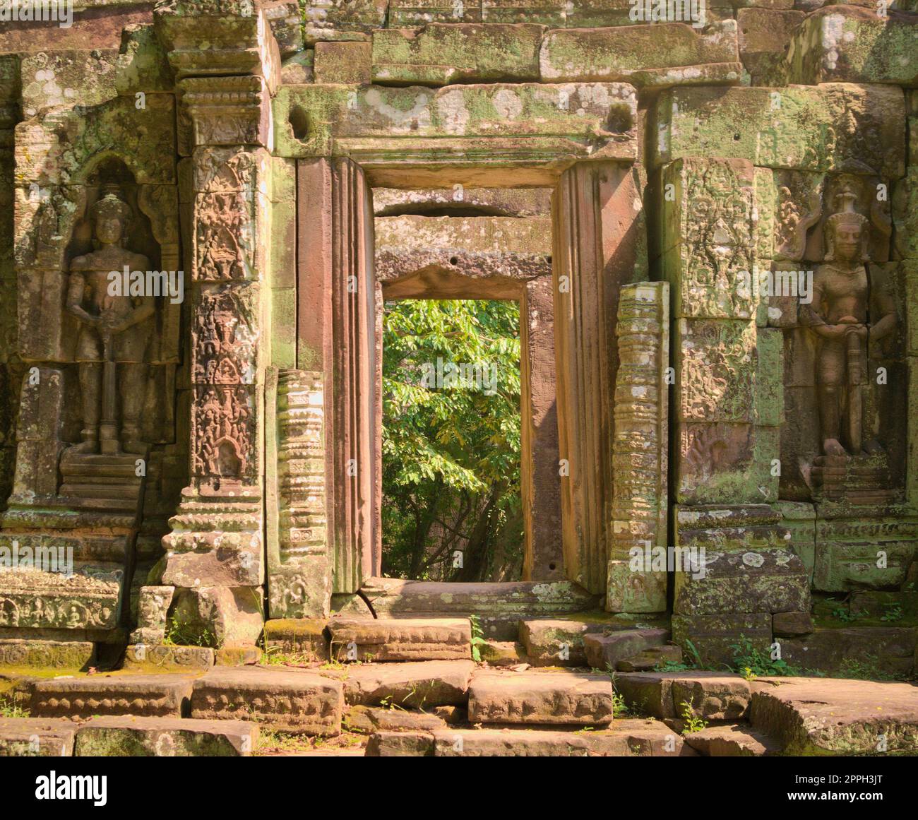 Stone doorway guarded by two warrior statues at Ta Prohm temple ruins ...