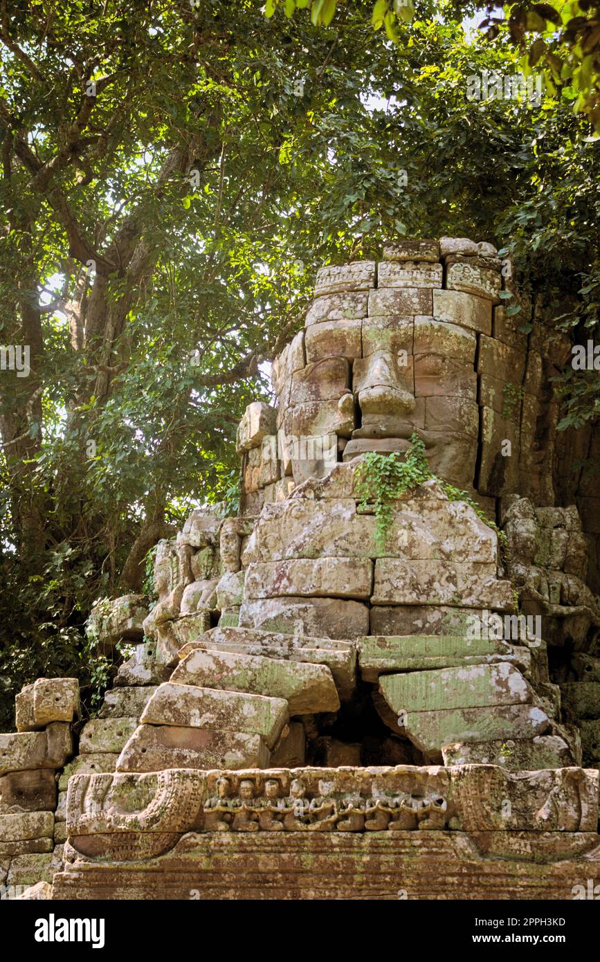 Stone face tower over the entrance gate of Ta Prohm temple, located in ...