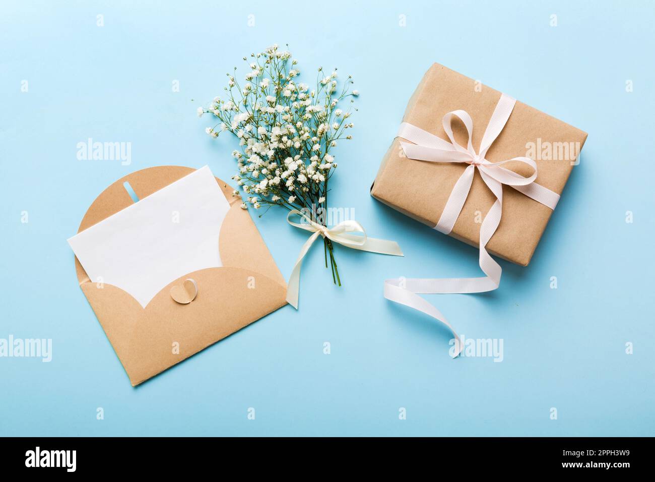 Wedding mockup with white paper list and flowers gypsophila on colored ...