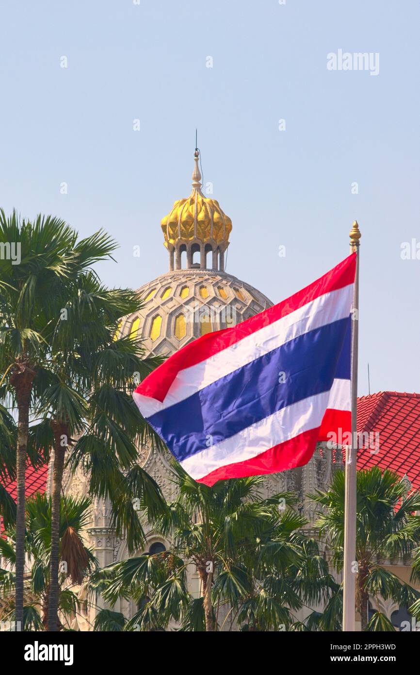 Flag of Thailand waving in front of the dome of the Government House of ...