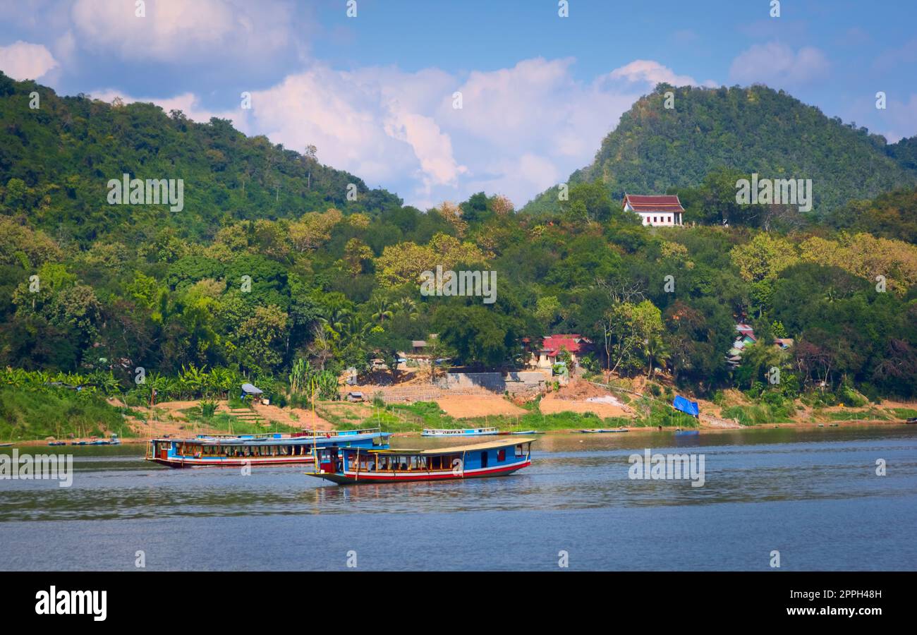 Long boats and barges sailing the Mekong River near Luang Prabang, Laos ...