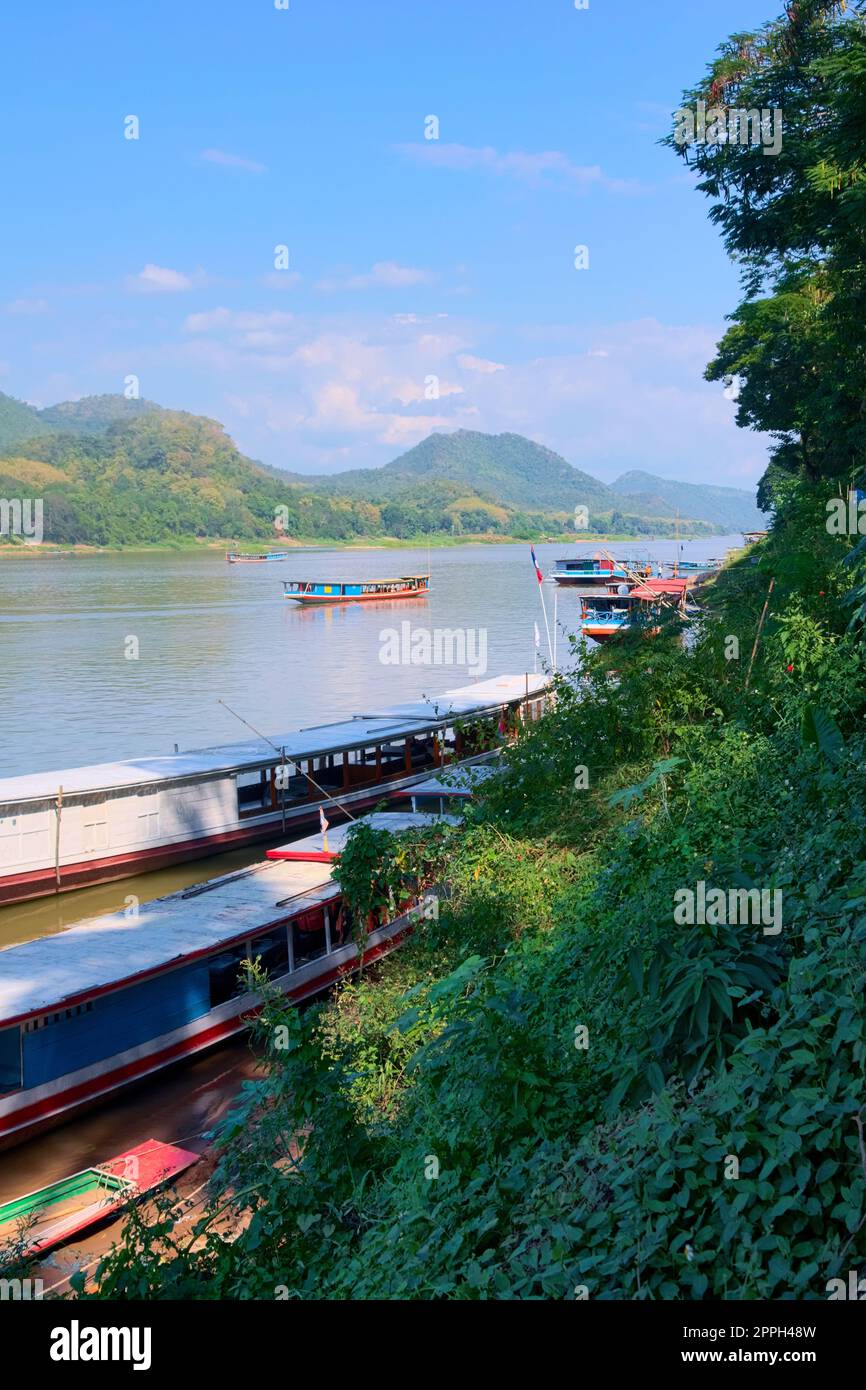 Long boats and barges sailing on the Mekong River near Luang Prabang ...