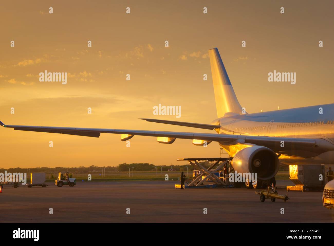 Airport ground crew loading cargo and luggage on a commercial aircraft ...