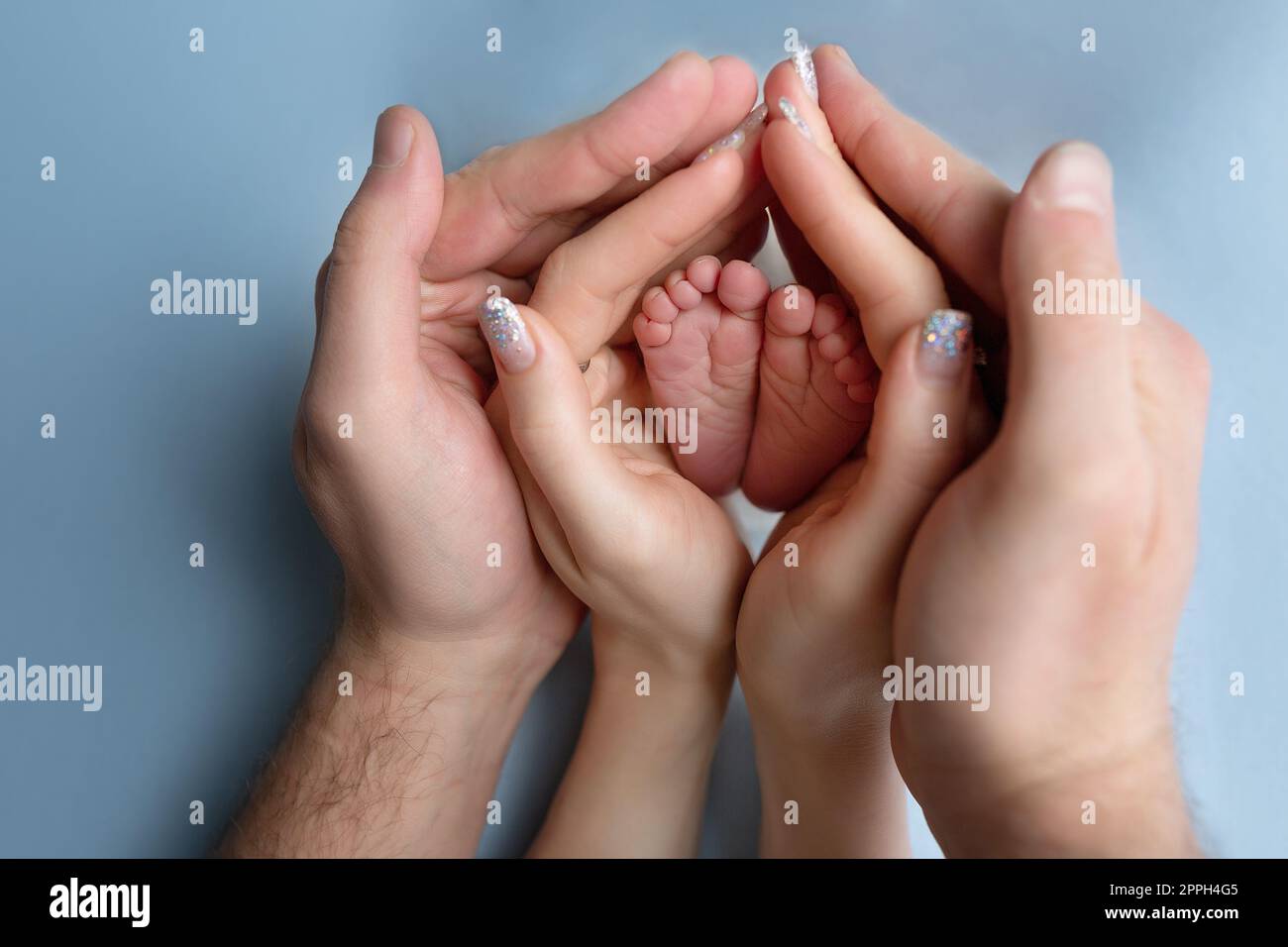 hands of parents and children on a white background. legs of a newborn ...