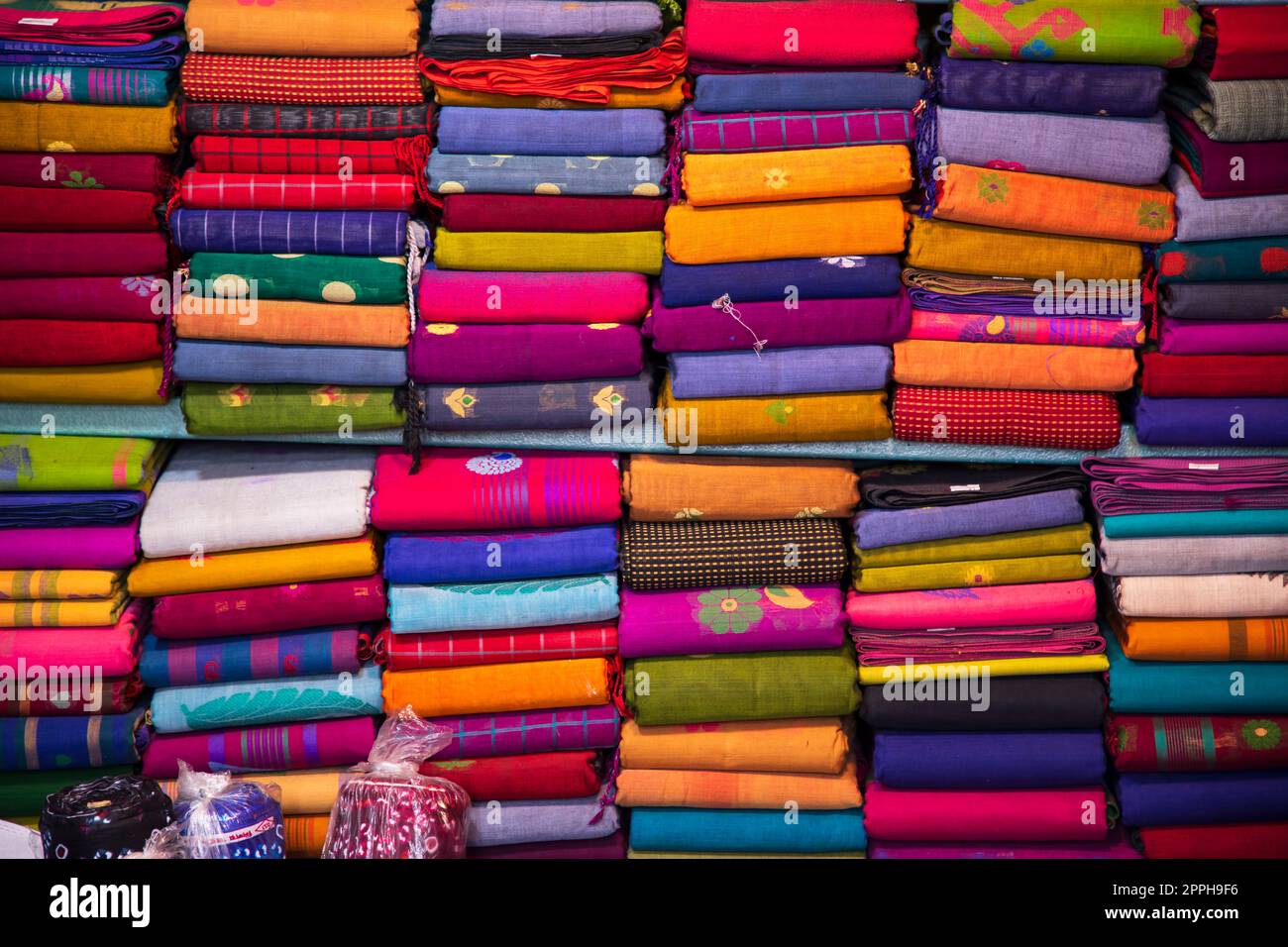 Artistic variety shade tone colors Saree's stacked on retail Shop Shelf ...