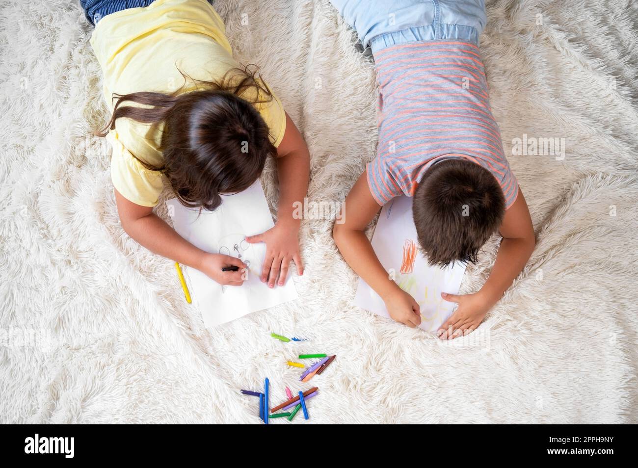 Siblings playing together at home. Top view of little boy and girl ...