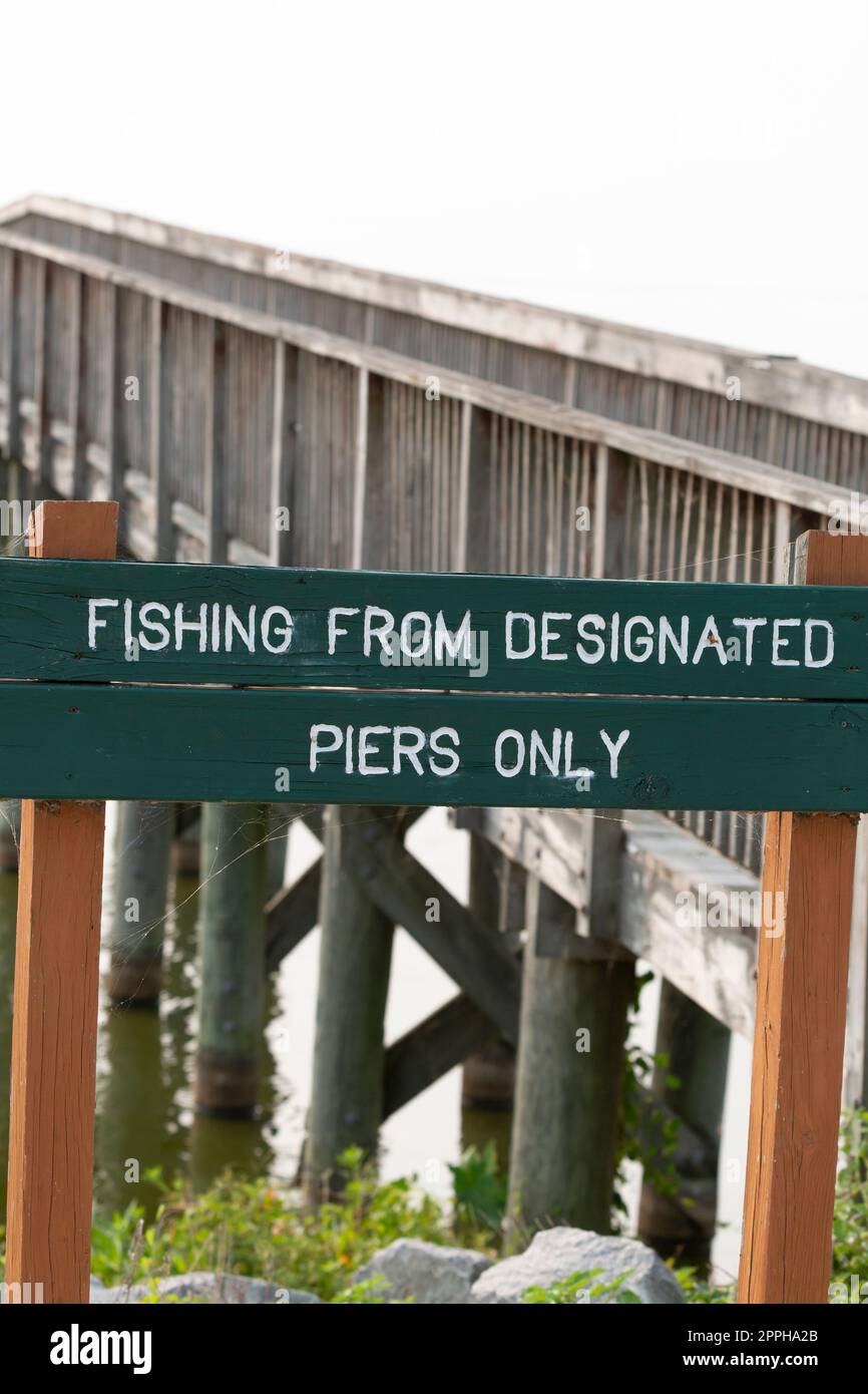 Fishing From Designated Piers Only Sign Stock Photo - Alamy