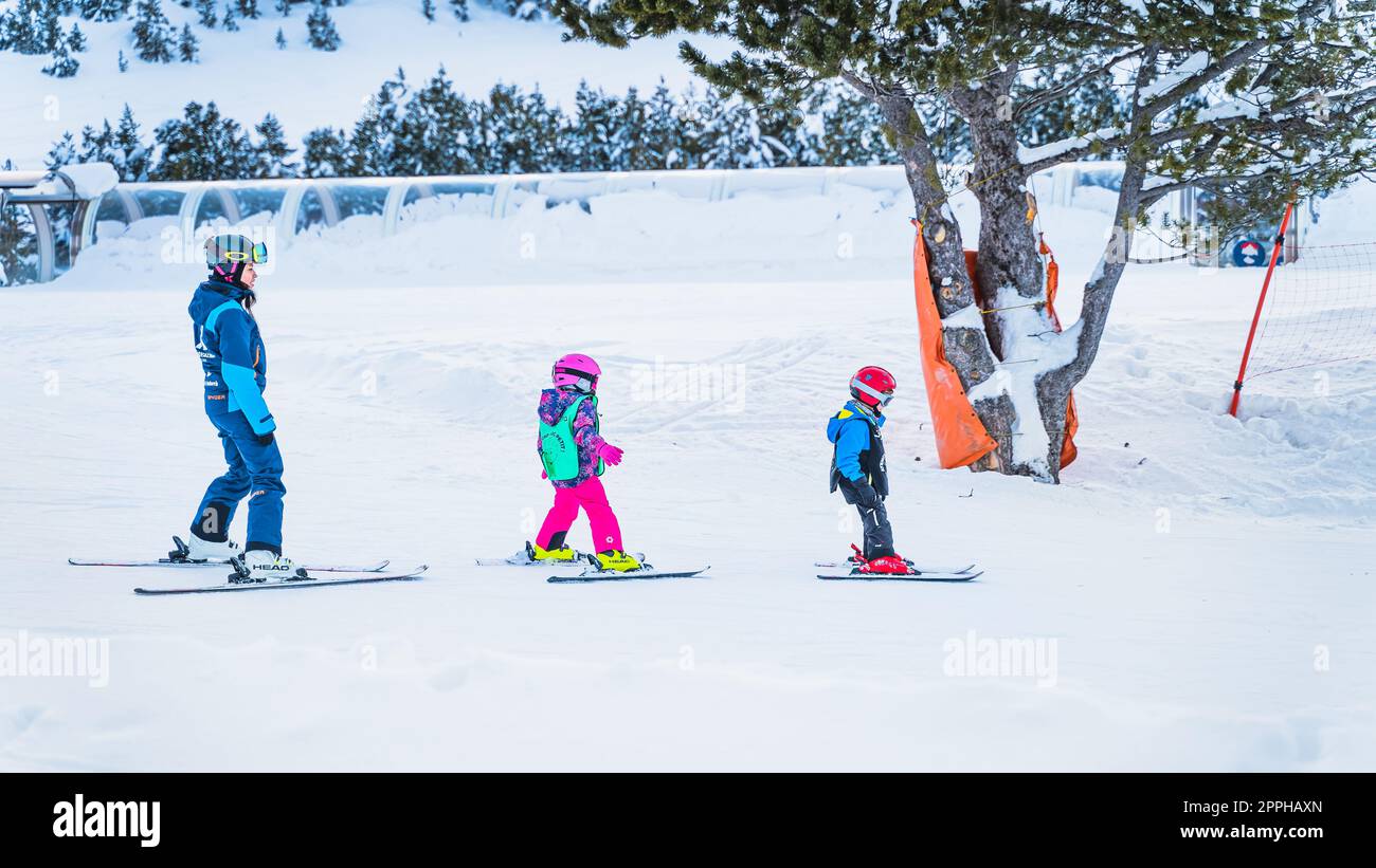 Woman ski trainer teaching young group of kids how to ski. Andora Stock ...