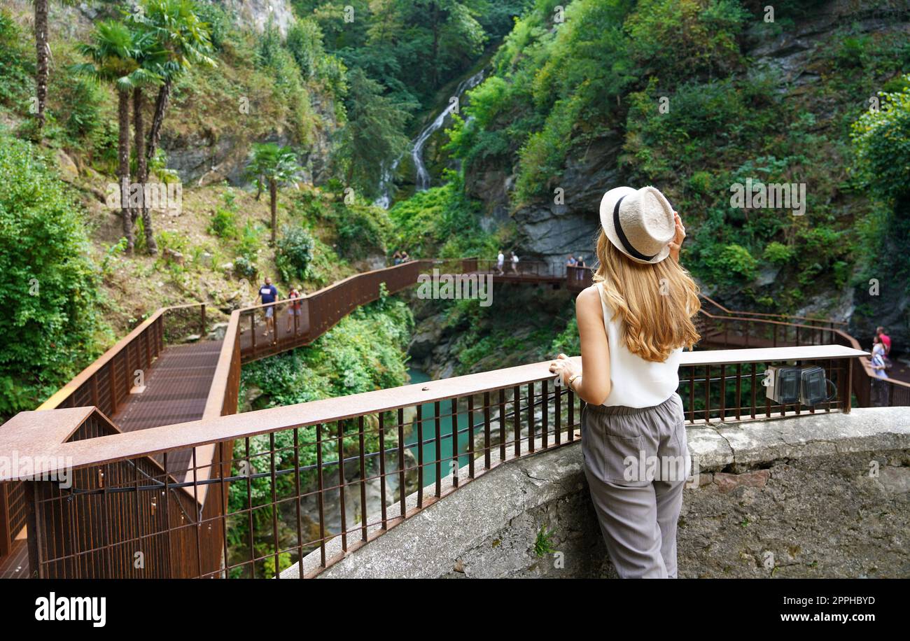 Girl on the path into the wild enjoying landscape with waterfalls and ...