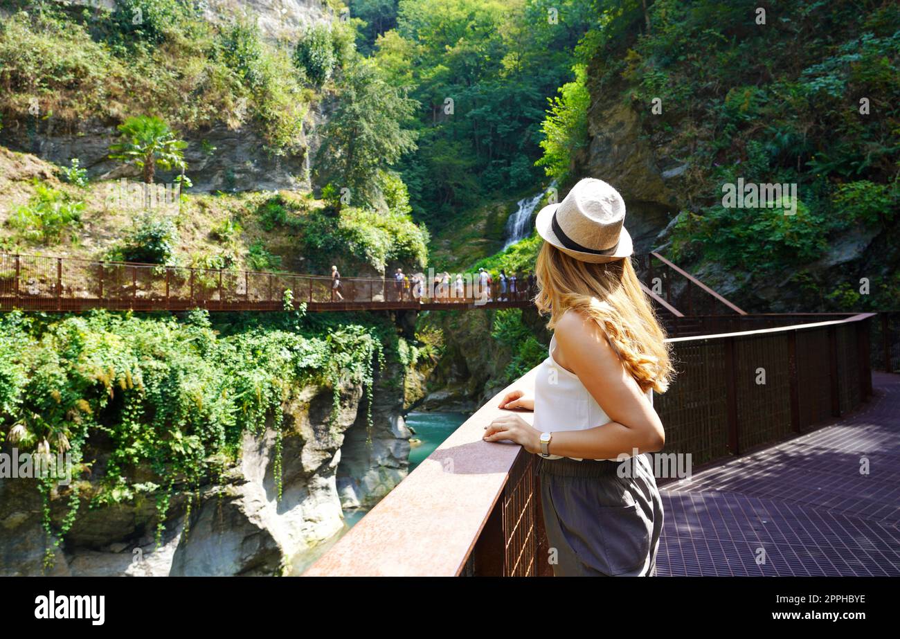Young woman walking on the path into the wild enjoying landscape with ...