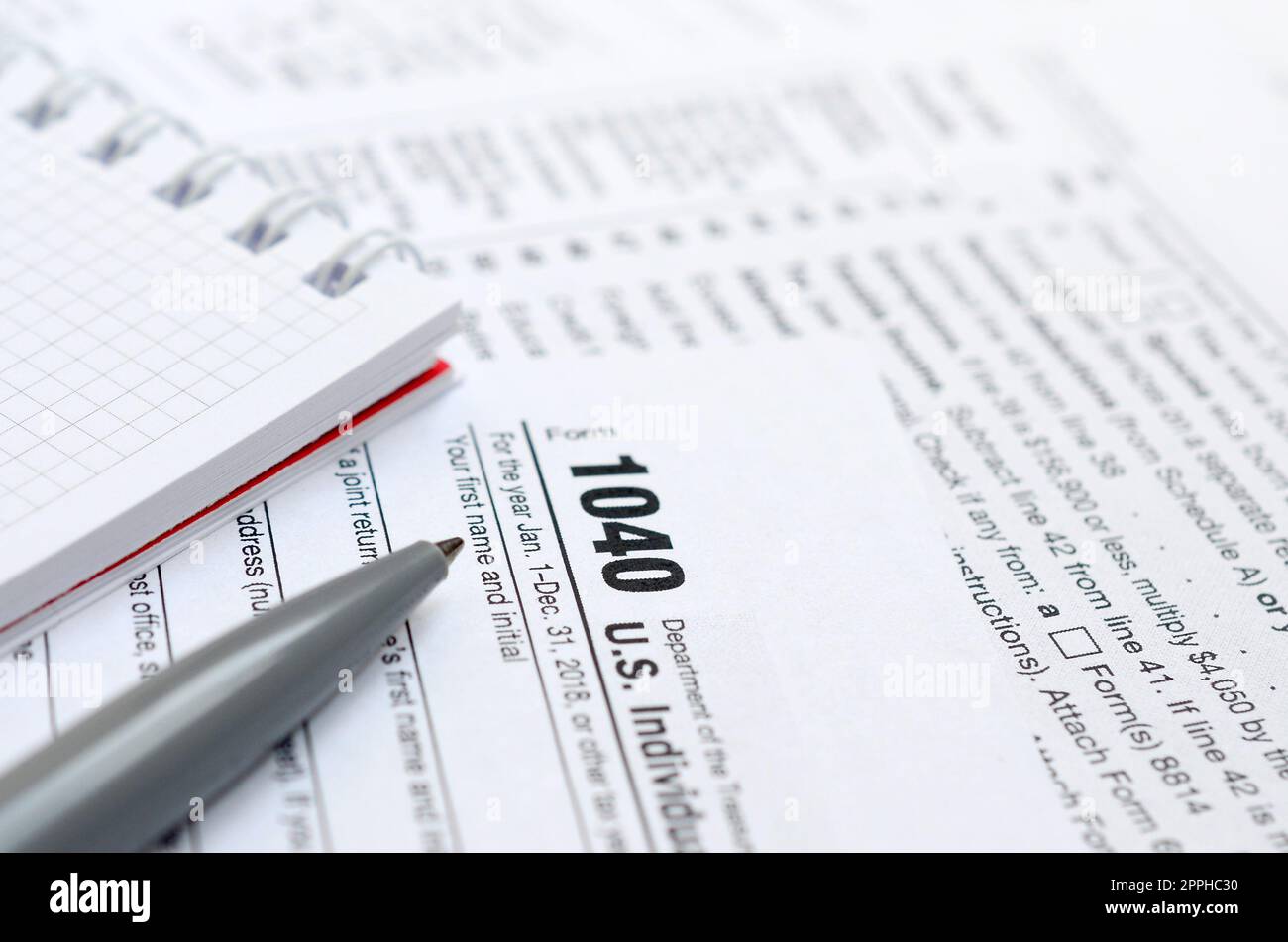 The pen and notebook is lies on the tax form 1040 U.S. Individual ...
