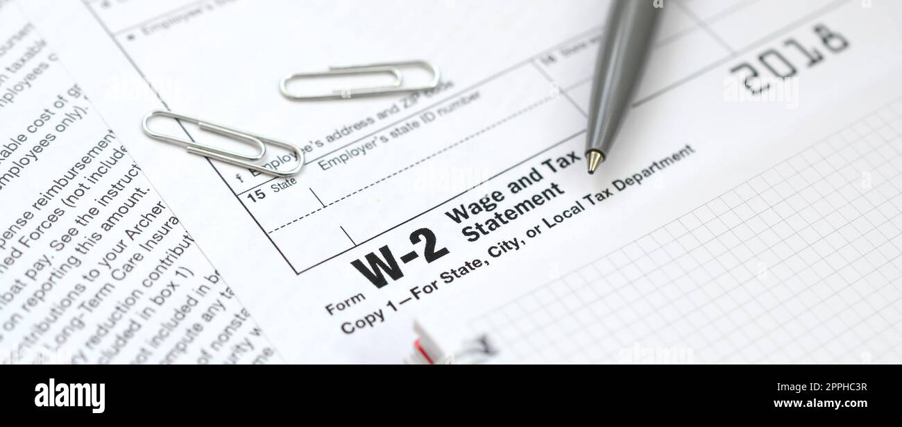 The pen and notebook on the tax form W-2 Wage and Tax Statement. The ...