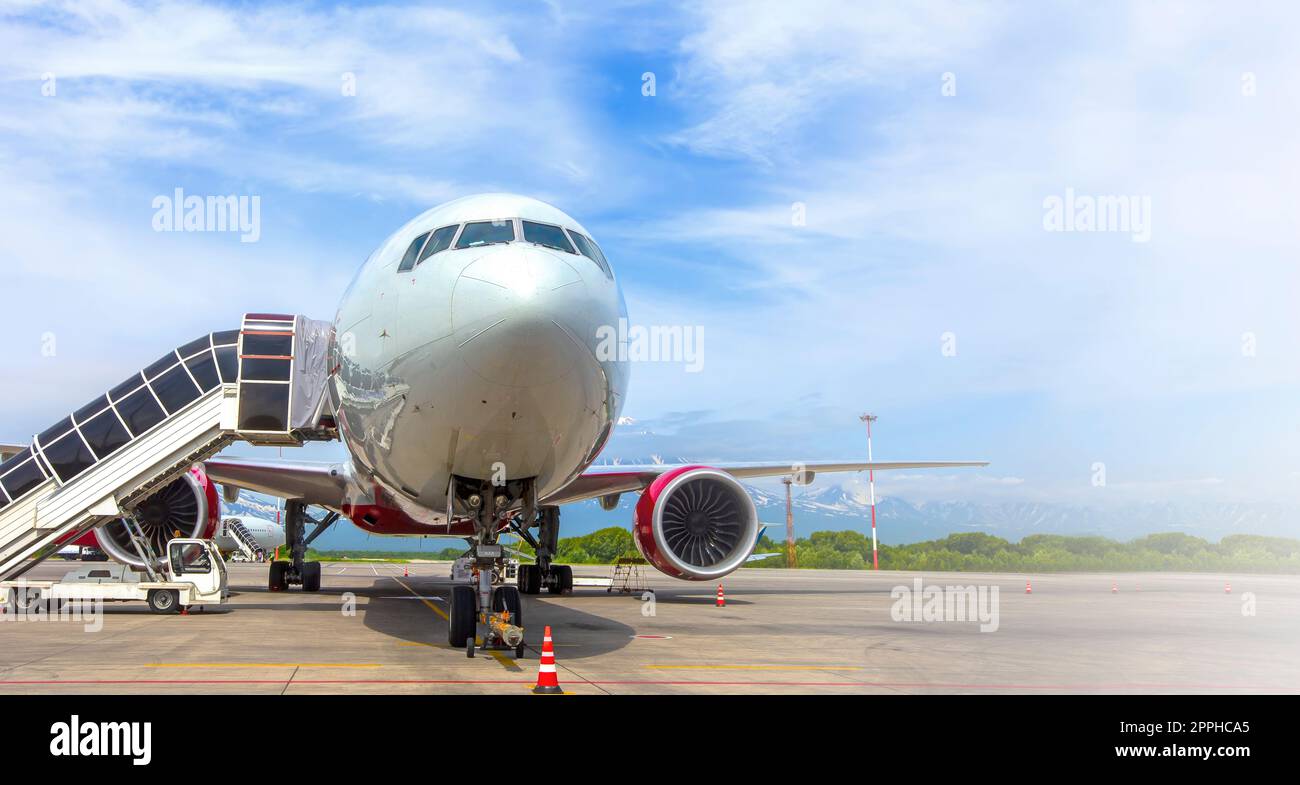 Airplane with a passenger boarding steps on the airport apron Stock ...
