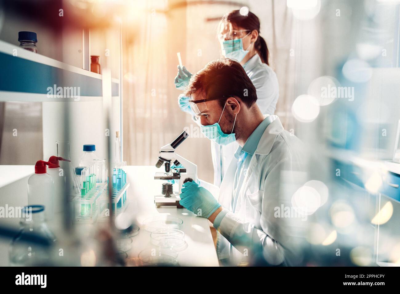 Doctor in the laboratory analyzes samples of codiv-9 under a microscope ...