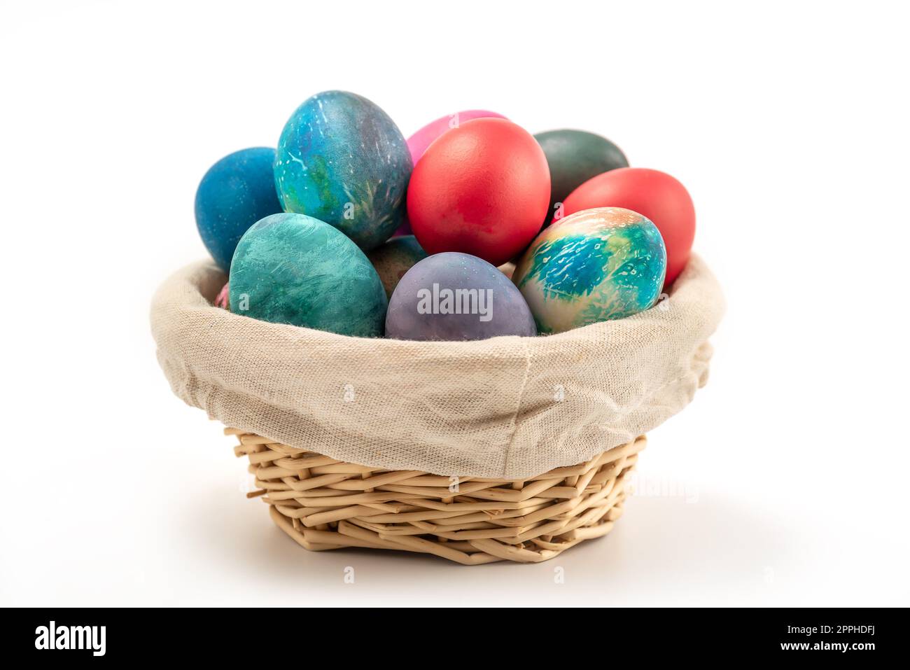 Multi colors Easter eggs in the woven basket isolated on white ...