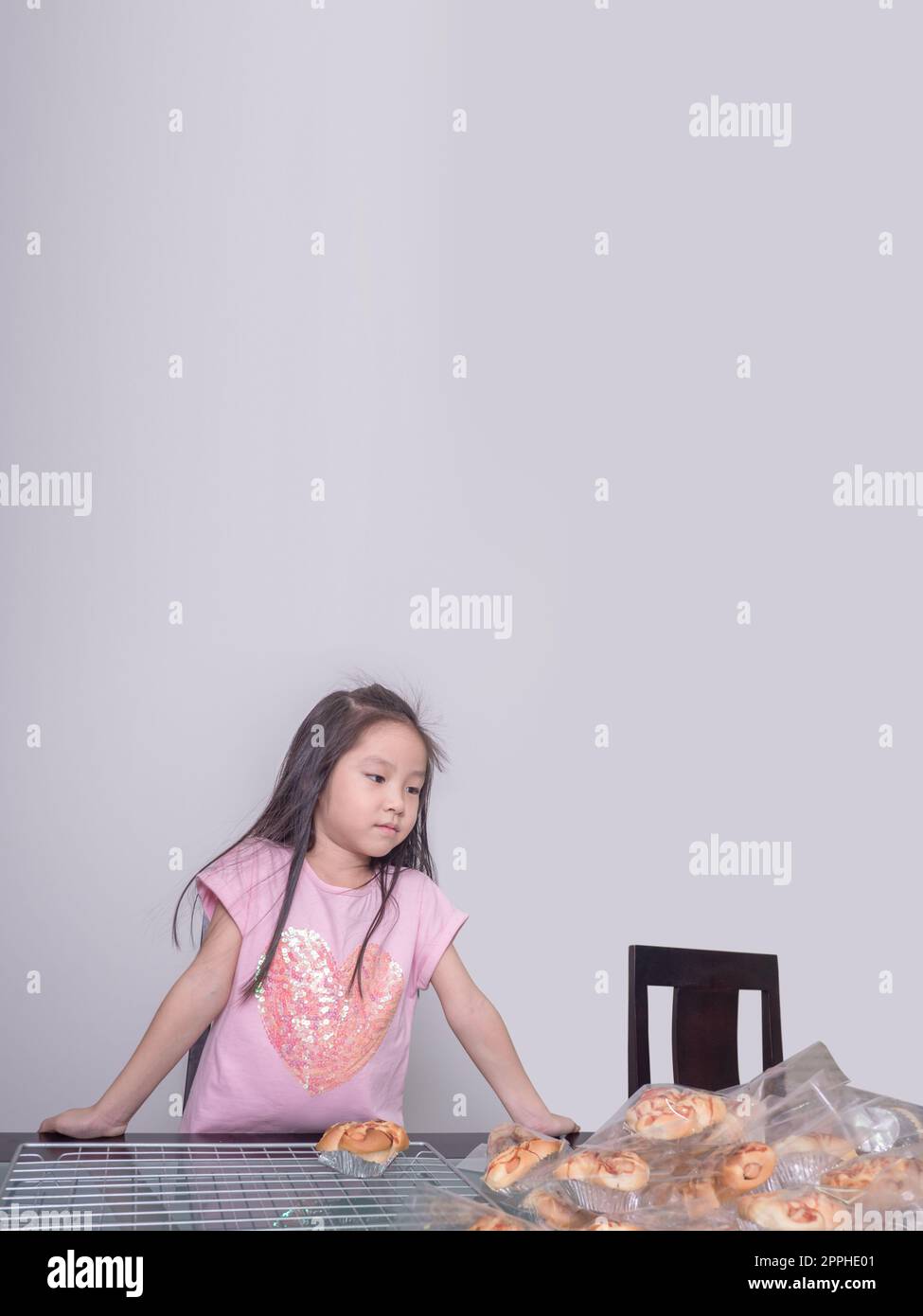 Adorable kid girl separate packing baked pork sausage with mayonnaise ...