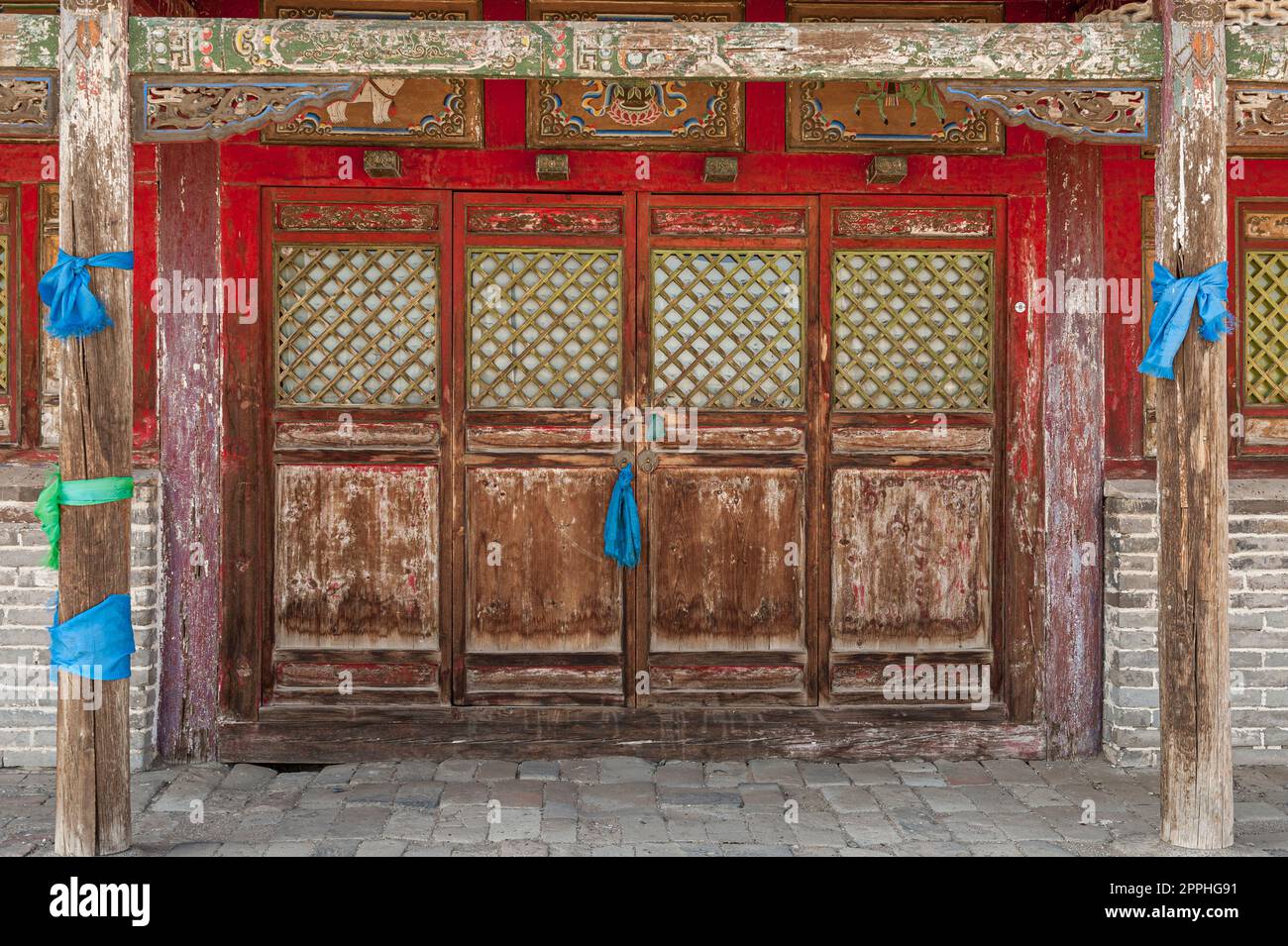 The closed, slightly weathered and colorful wooden doors in a monastery ...