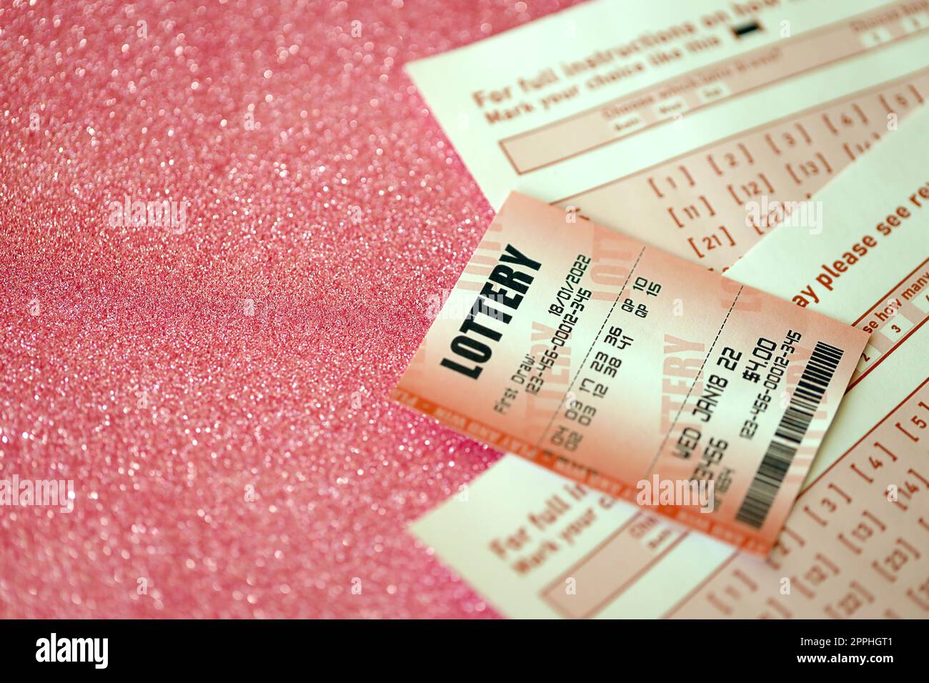 Red lottery ticket lies on pink gambling sheets with numbers for ...