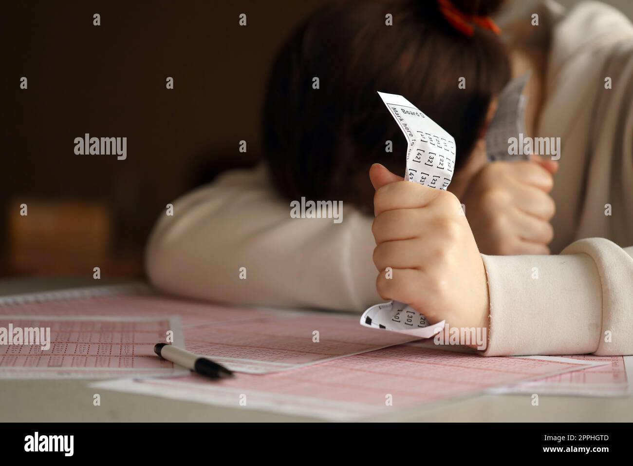 A sad young girl suffers from a loss after looking the unlucky result ...