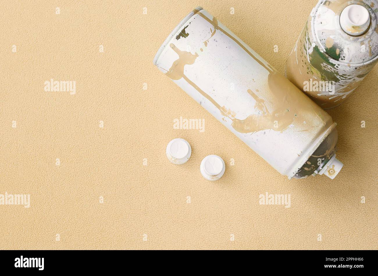 Some used orange aerosol spray cans and nozzles with paint drips lies ...