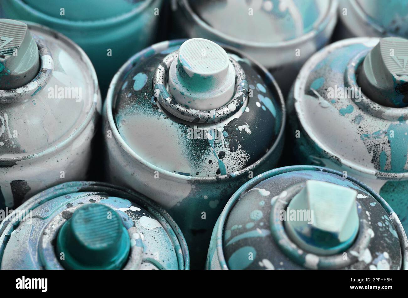 A lot of used spray cans of paint close-up. Dirty and smeared cans for ...