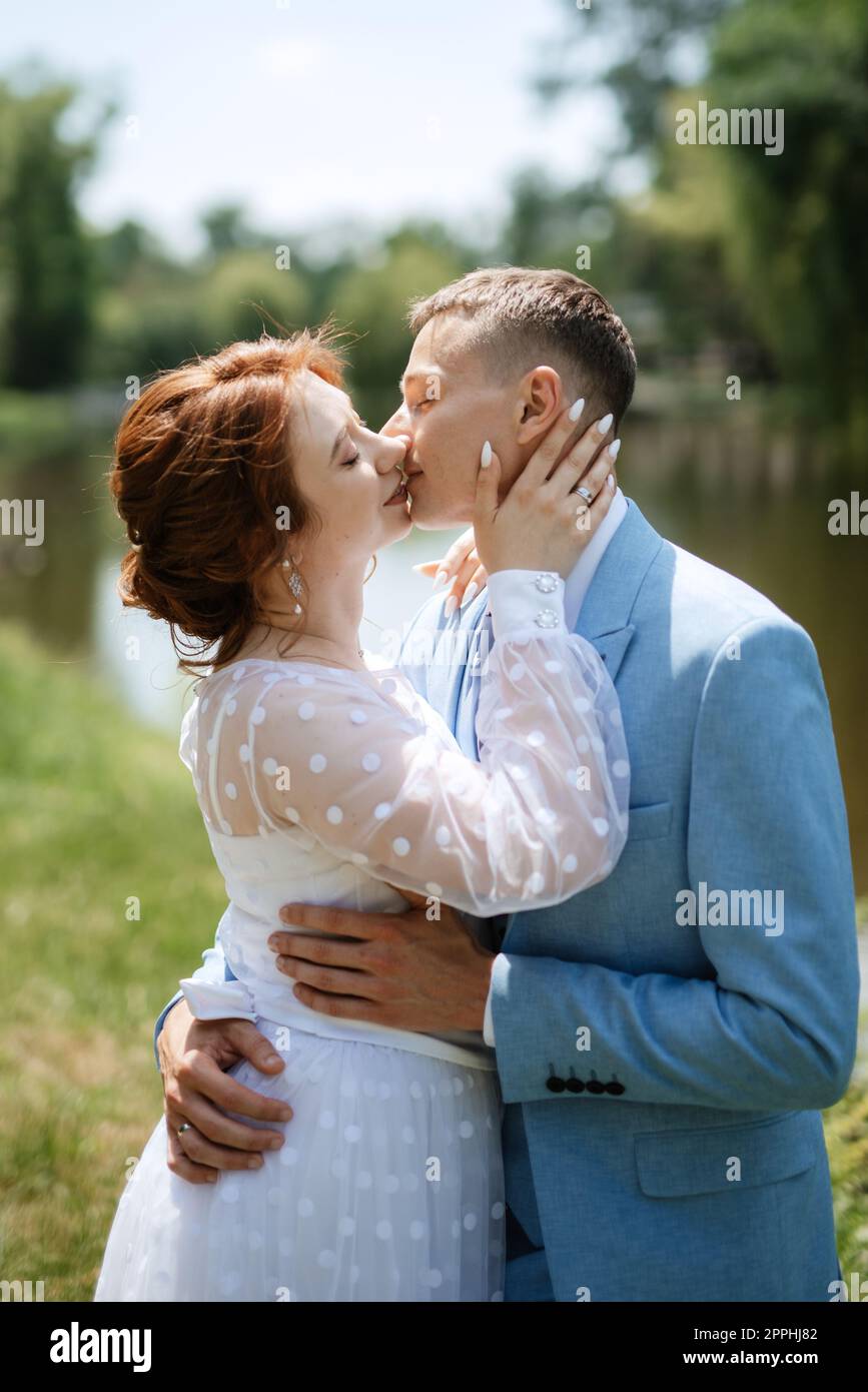 bride in a light wedding dress to the groom in a blue suit Stock Photo ...