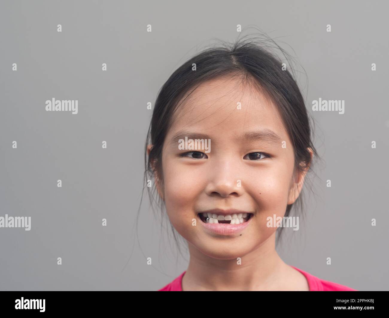 Asian little cute girl smile with her broken tooth , grey background Stock Photo - Alamy