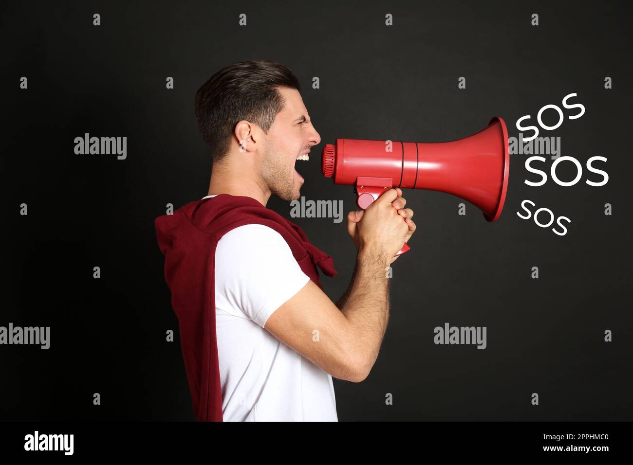 Man with red megaphone and words SOS on black background. Asking for ...