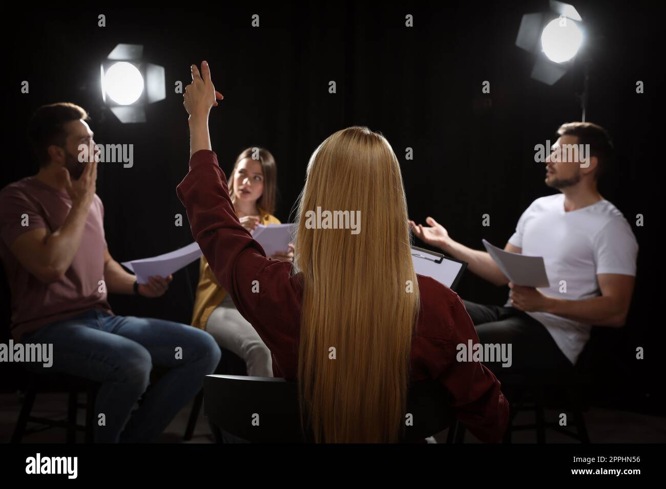Professional actors reading their scripts during rehearsal in theatre ...