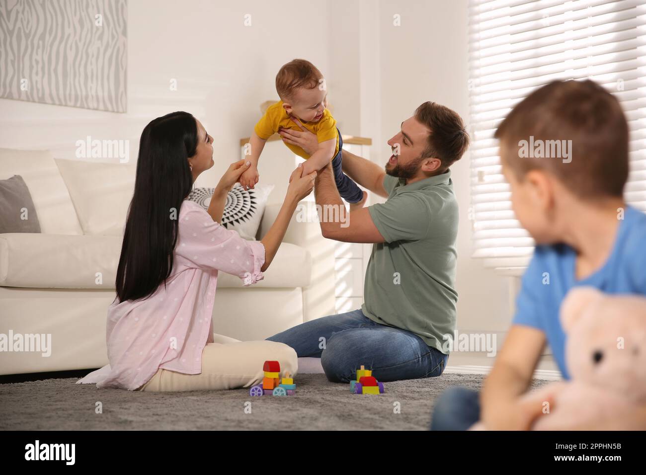 Unhappy little boy feeling jealous while parents spending time with his ...