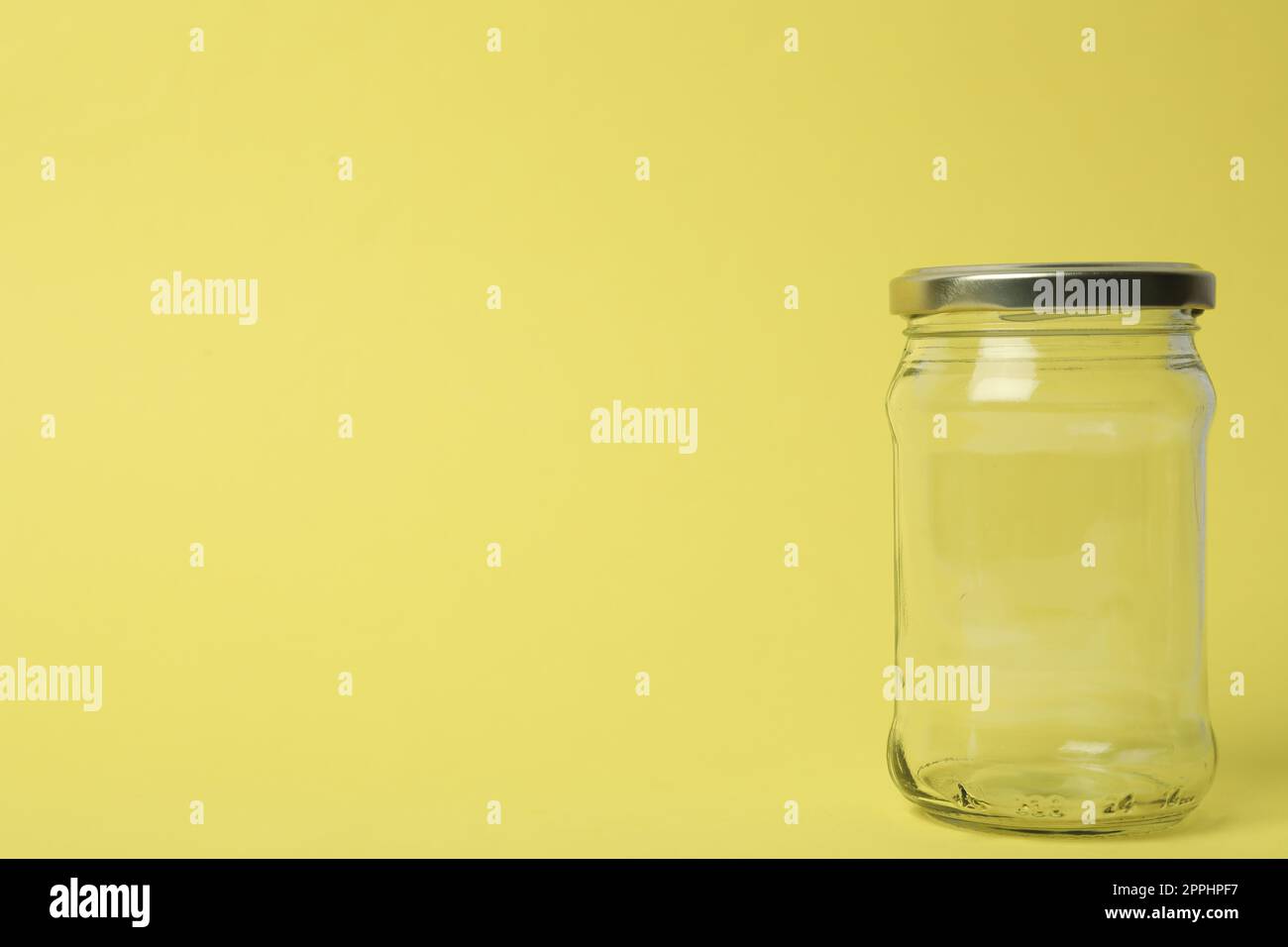 Closed empty glass jar on light yellow background, space for text Stock ...