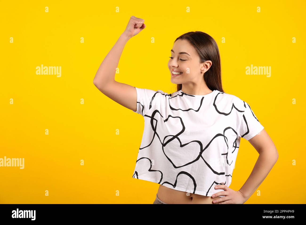 Strong woman as symbol of girl power on yellow background, space for ...