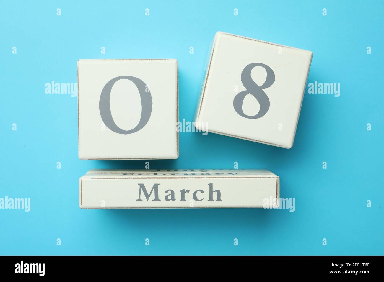 Wooden block calendar with date 8th of March on light blue background ...