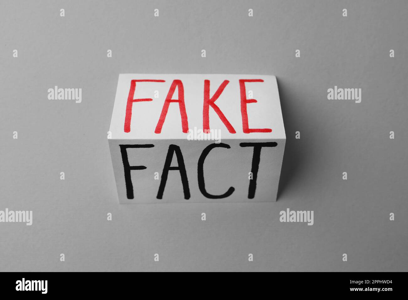 Sheet of paper with words Fact and Fake on light grey background, top ...