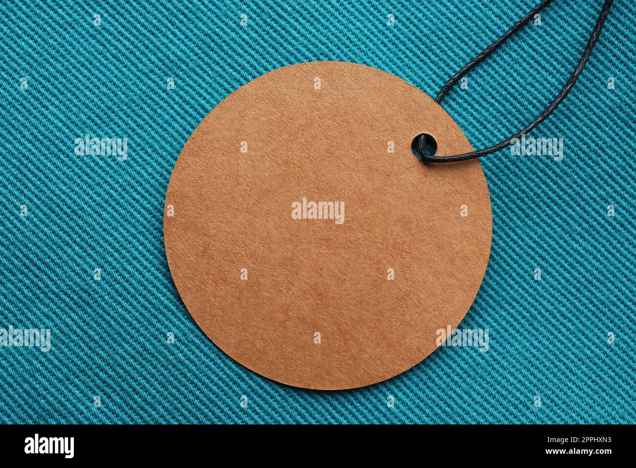 Circle shaped tag with space for text on dark turquoise fabric, top ...