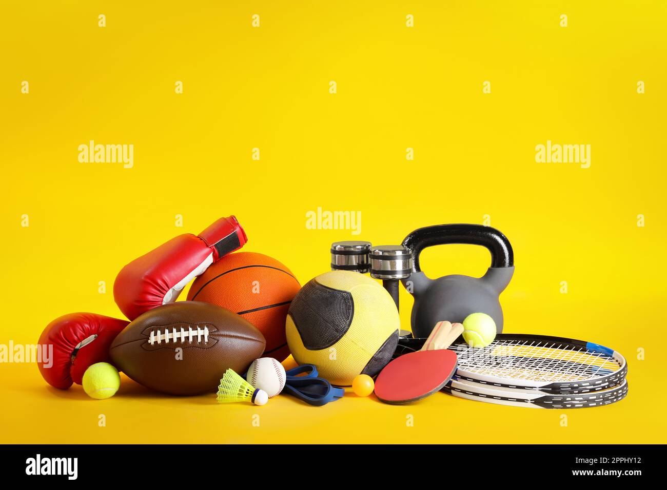 Set of different sports equipment on yellow background Stock Photo - Alamy
