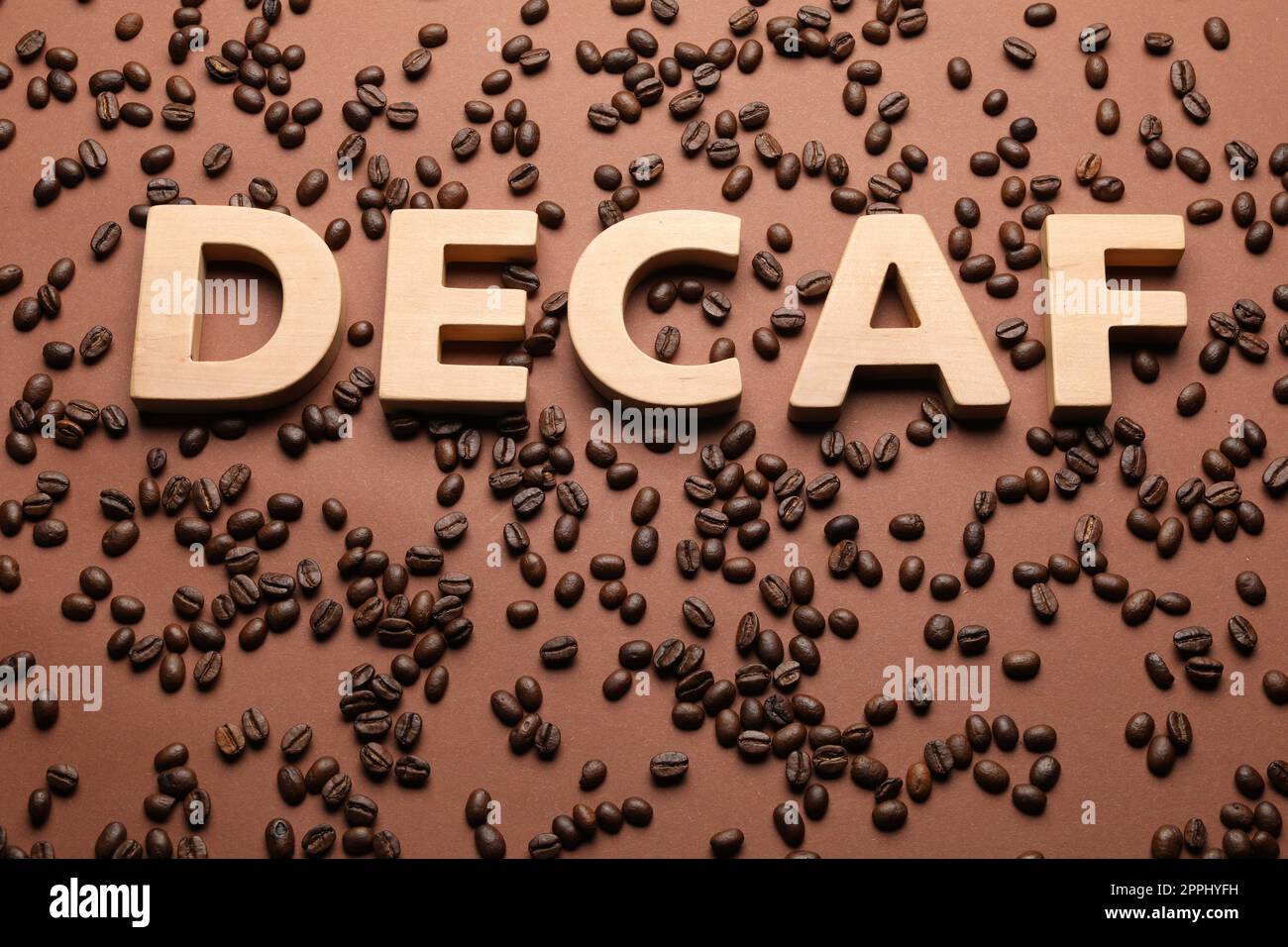 Word Decaf made of wooden letters on brown background with coffee beans ...