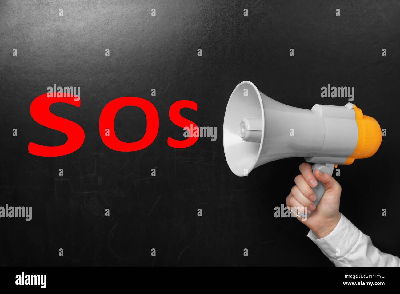 Man holding megaphone and word SOS near chalkboard. Asking for help ...