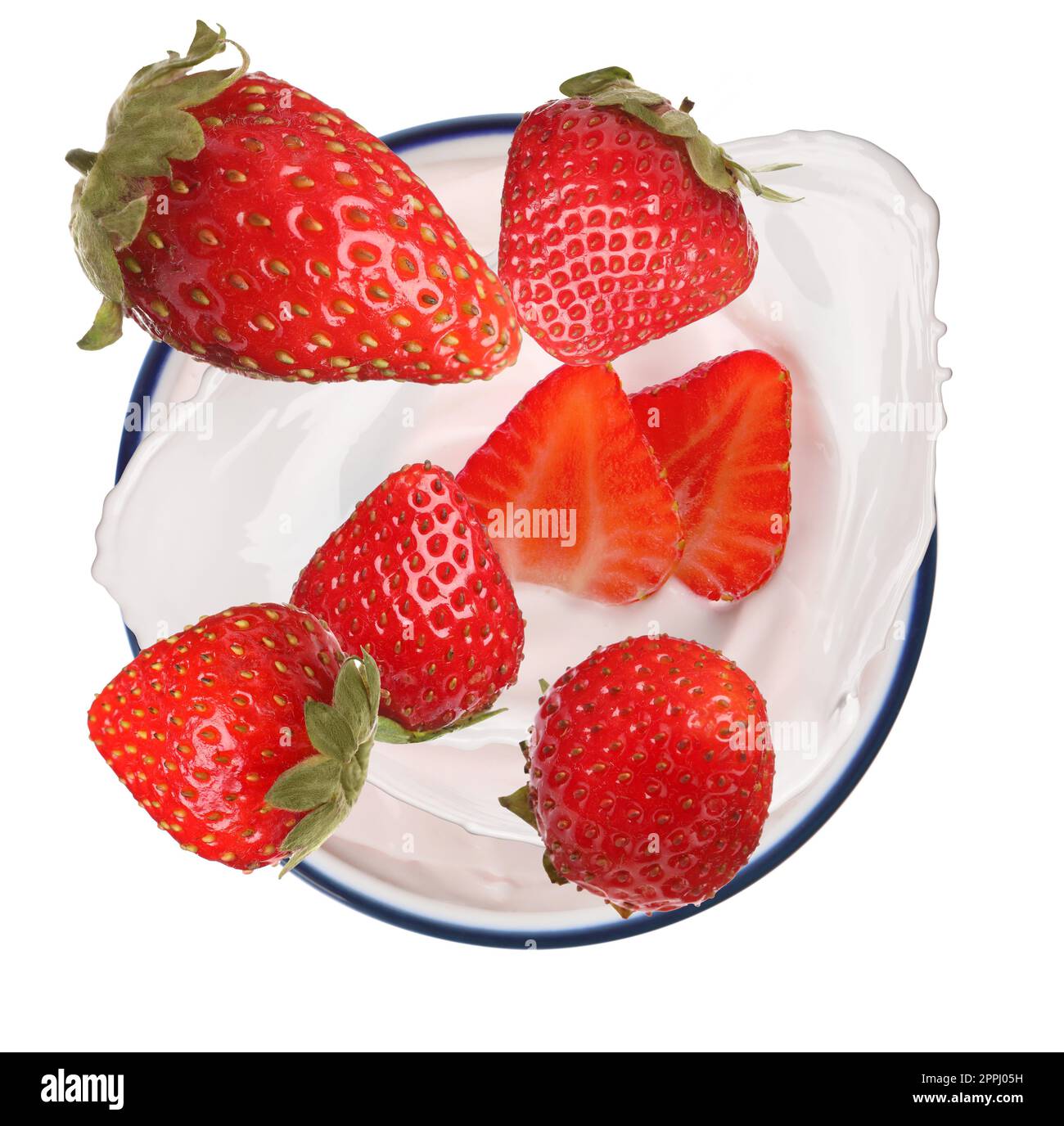 Delicious ripe strawberries falling into bowl with yogurt on white background, top view Stock ...